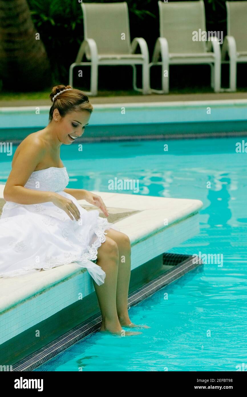 Side profile of a bride sitting at the poolside and smiling Stock Photo ...