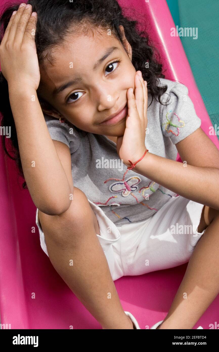 Portrait of a girl sitting on a slide Stock Photo - Alamy