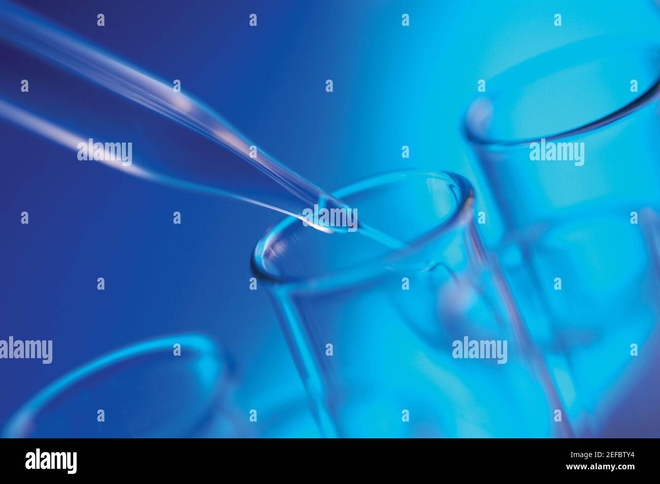 Close-up of a dropper pouring liquid into a test tube Stock Photo - Alamy