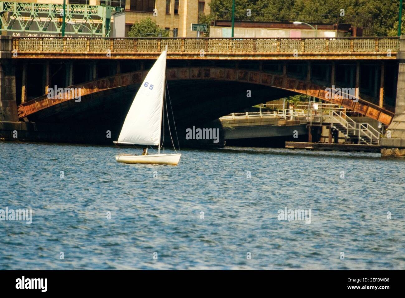 Sailboat in a river near an arch bridge, Boston, Massachusetts, USA ...