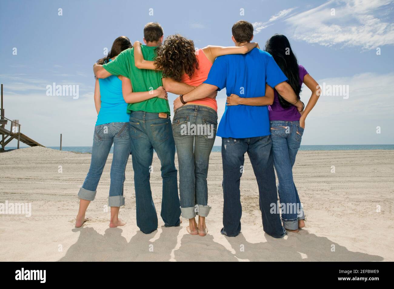 Rear view of five people standing on the beach Stock Photo - Alamy
