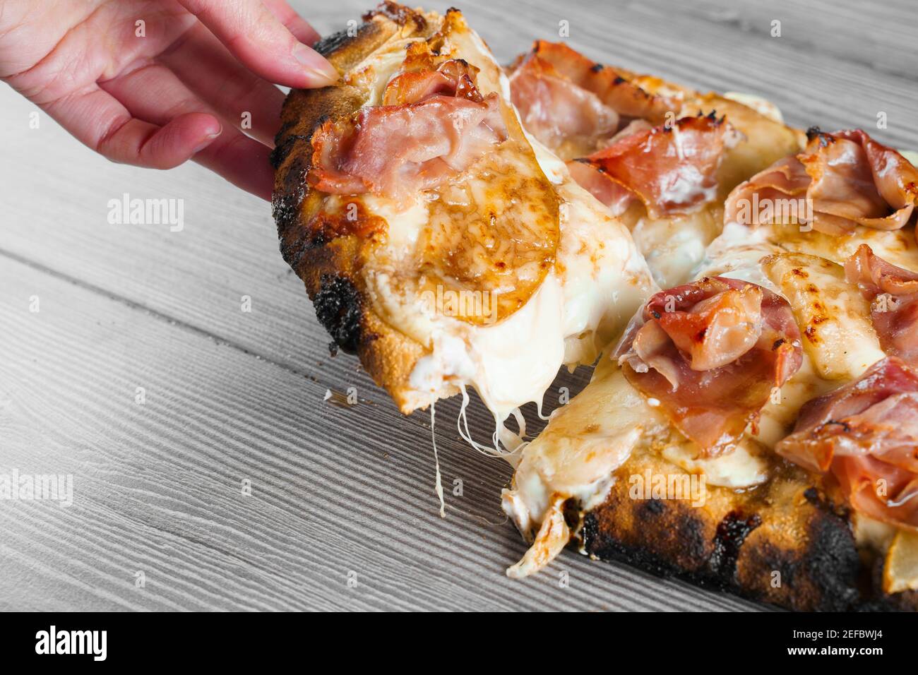 Mozzarella stretching cheese on pinsa romana gourmet italian cuisine ...