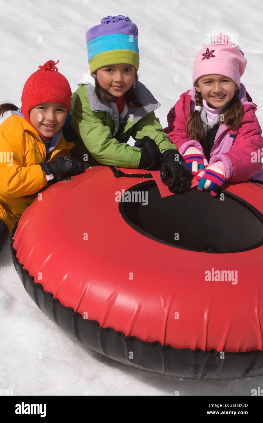 Portrait of three girls sitting near an inner tube Stock Photo - Alamy