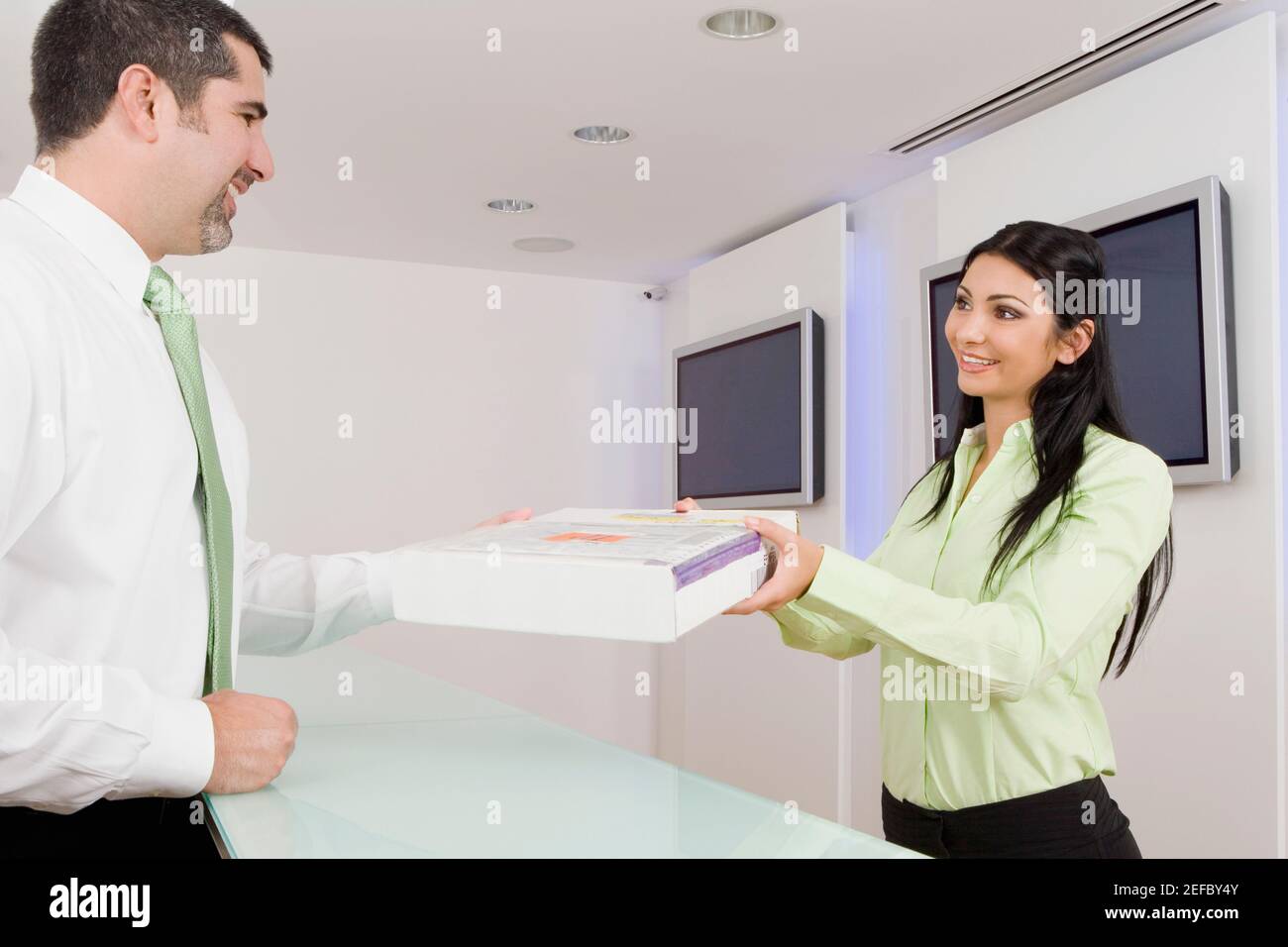 Businesswoman receiving a parcel from a businessman Stock Photo - Alamy