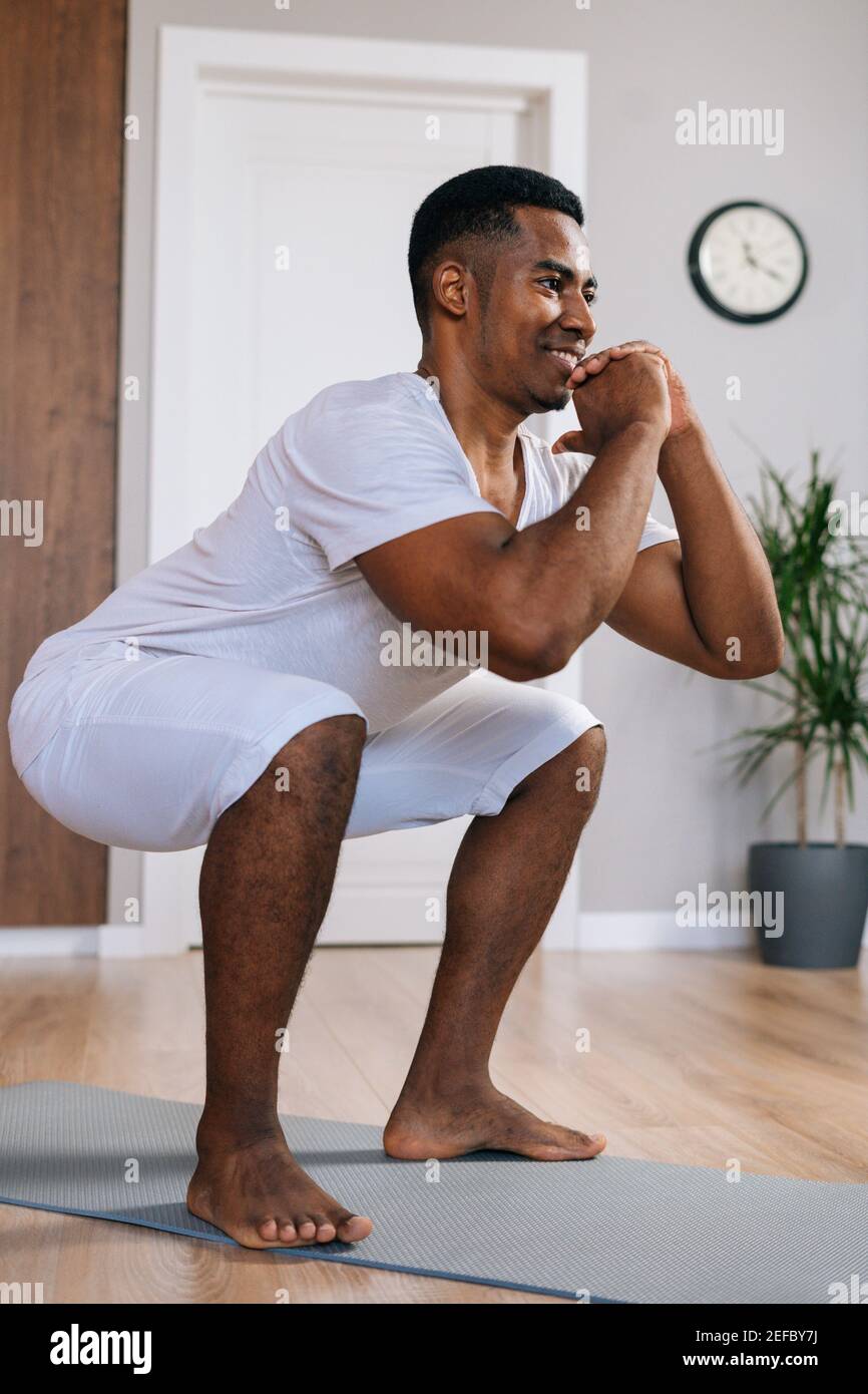 Close-up side view of cheerful African-American man exercising and ...