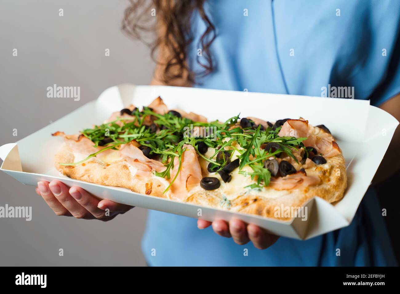 Pinsa romana in white delivery box. Courier holding crocchiarella ...