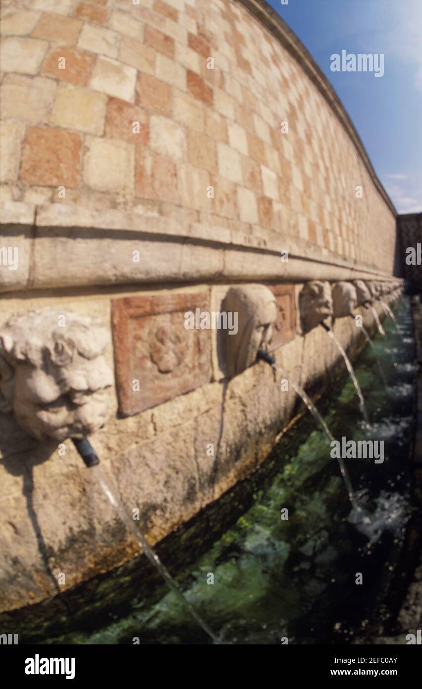 Water flowing from the mouth of statues at a water fountain Stock Photo ...
