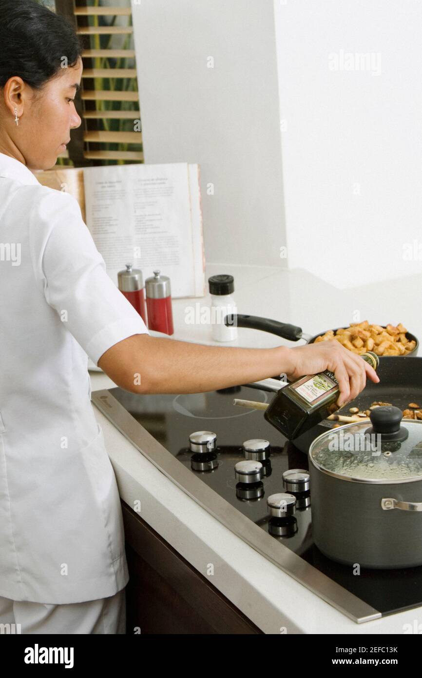 Rear view of a maid preparing food in the kitchen Stock Photo - Alamy