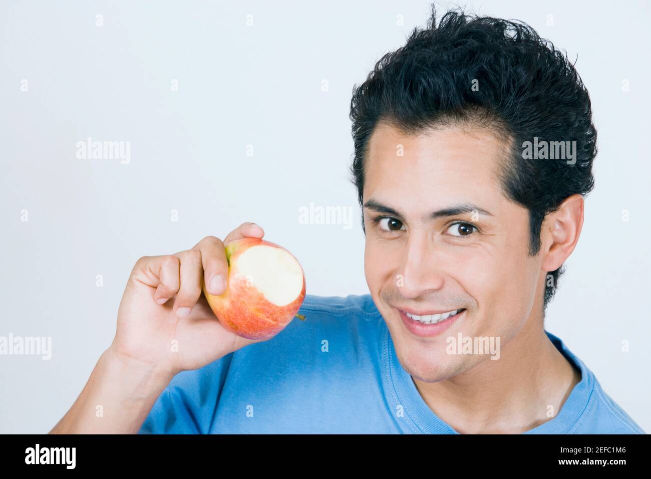 Portrait of a young man showing a missing bite apple and smiling Stock ...