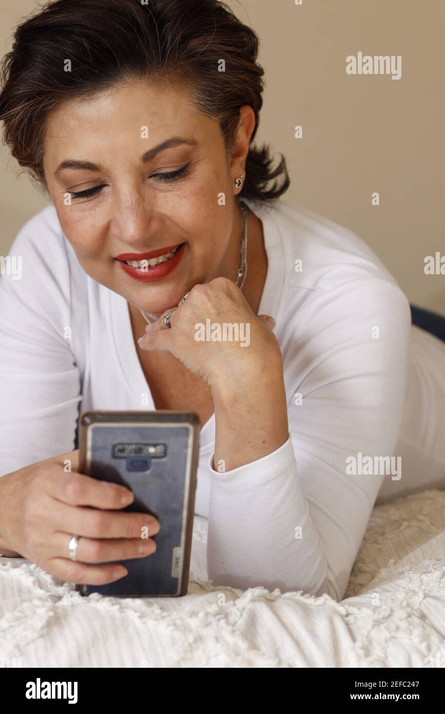 Beautiful young girl in her bedroom using the phone Stock Photo - Alamy