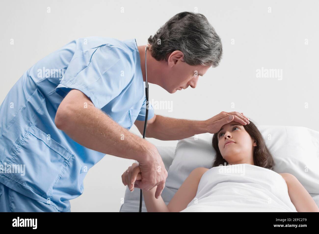 Side profile of a male surgeon examining a young woman Stock Photo - Alamy