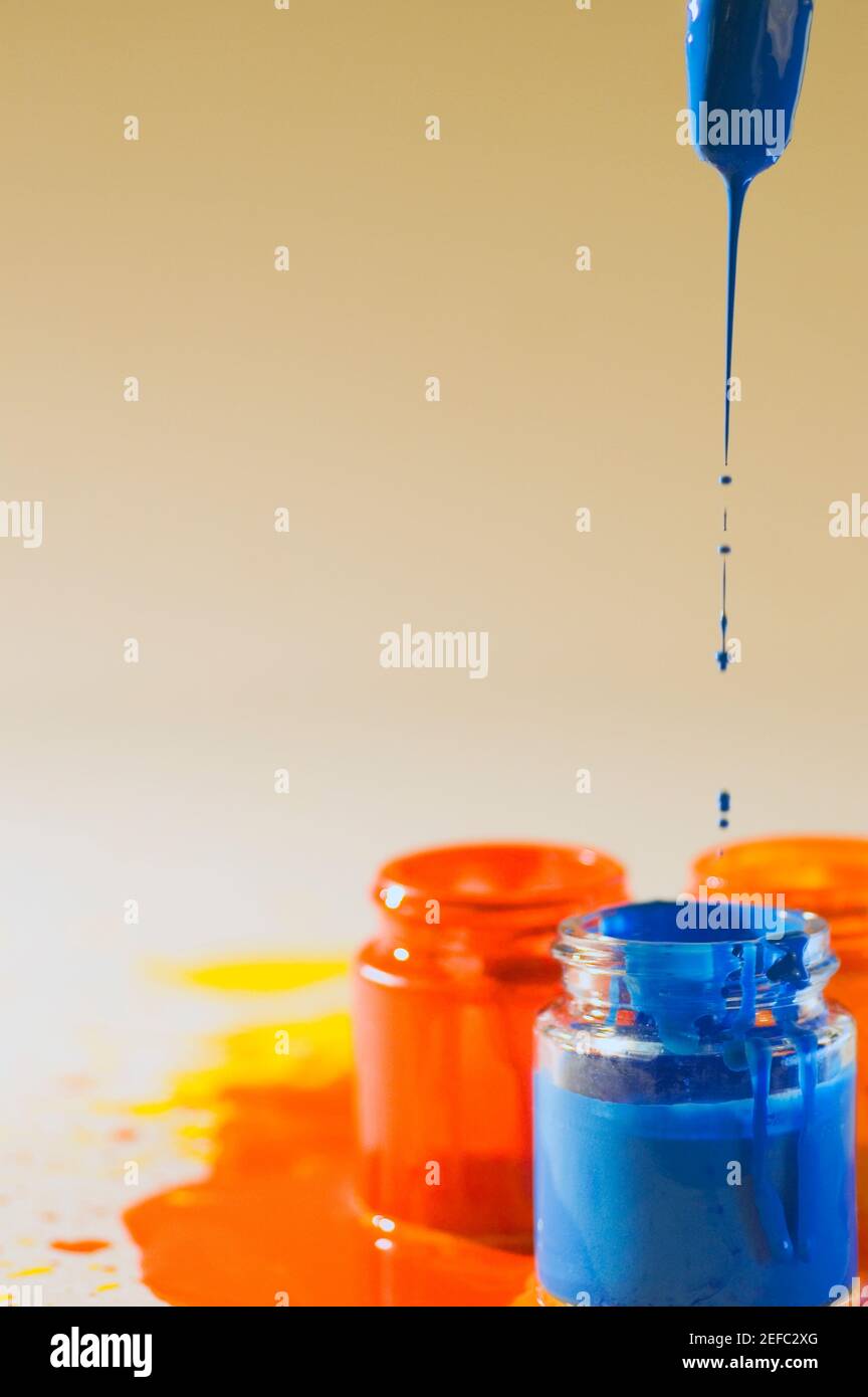 Paint dripping from a paintbrush into a bottle of paint Stock Photo - Alamy