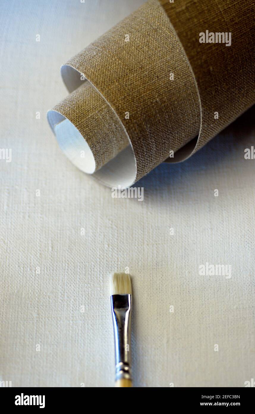 High angle view of a roll of canvas and a paintbrush Stock Photo - Alamy