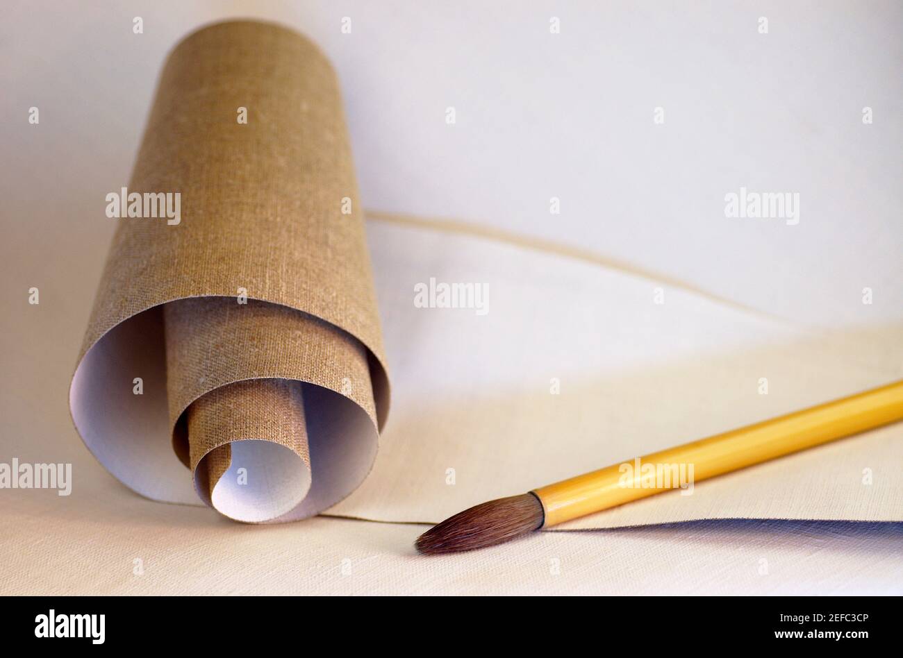 High angle view of a roll of canvas and a paintbrush Stock Photo - Alamy