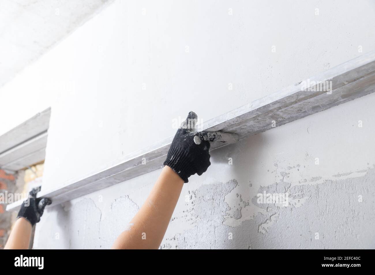 Builder Level out defects in concrete walls with cement plaster Stock ...