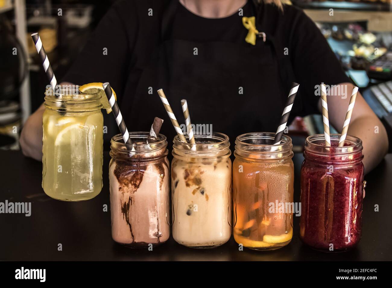 Waitress Holding Two Of The Refreshing Drinks In Glass Jars With