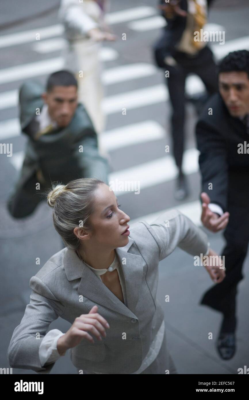 High angle view of business executives chasing a businesswoman Stock ...