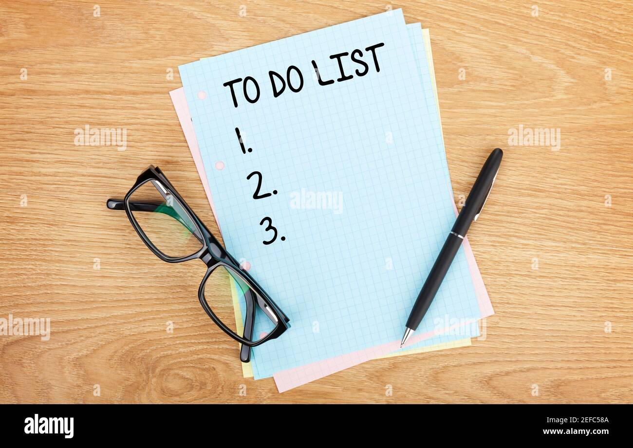 To do list paper with office supplies and glasses on wooden table ...