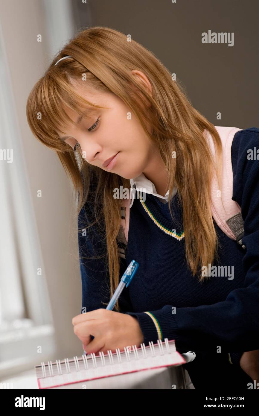 Close up of a teenage girl writing in a spiral notebook Stock Photo - Alamy