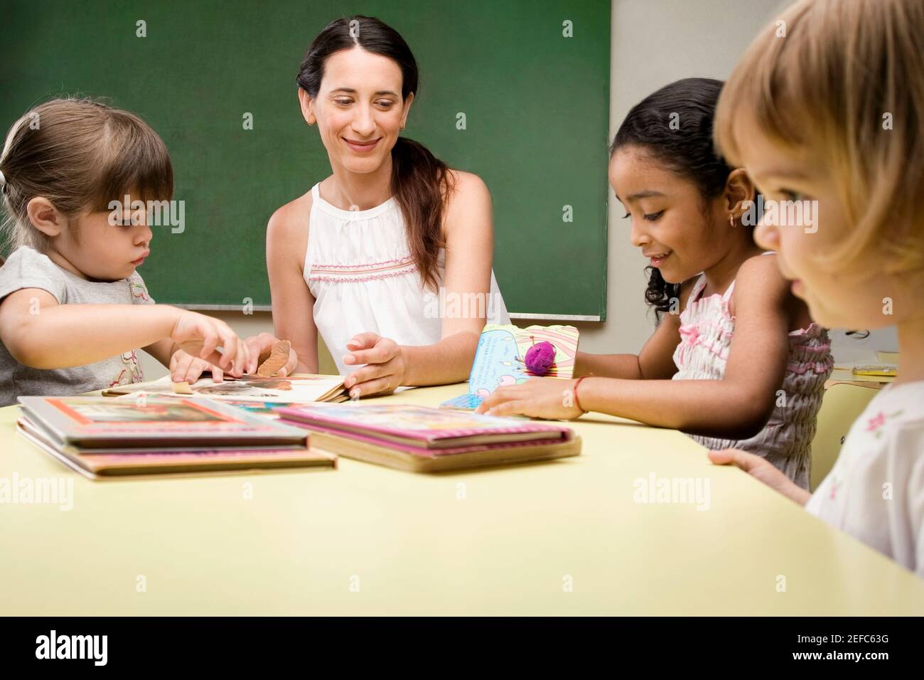 Female teacher teaching her students in a classroom Stock Photo - Alamy