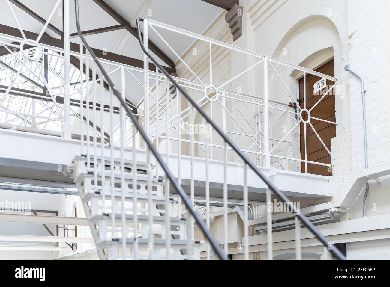 Old Victorian prison landing wing with bars and staircase of high ...
