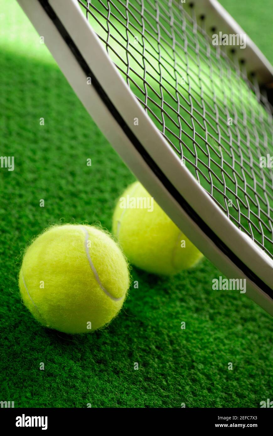 Close-up of two tennis balls with a tennis racket Stock Photo - Alamy