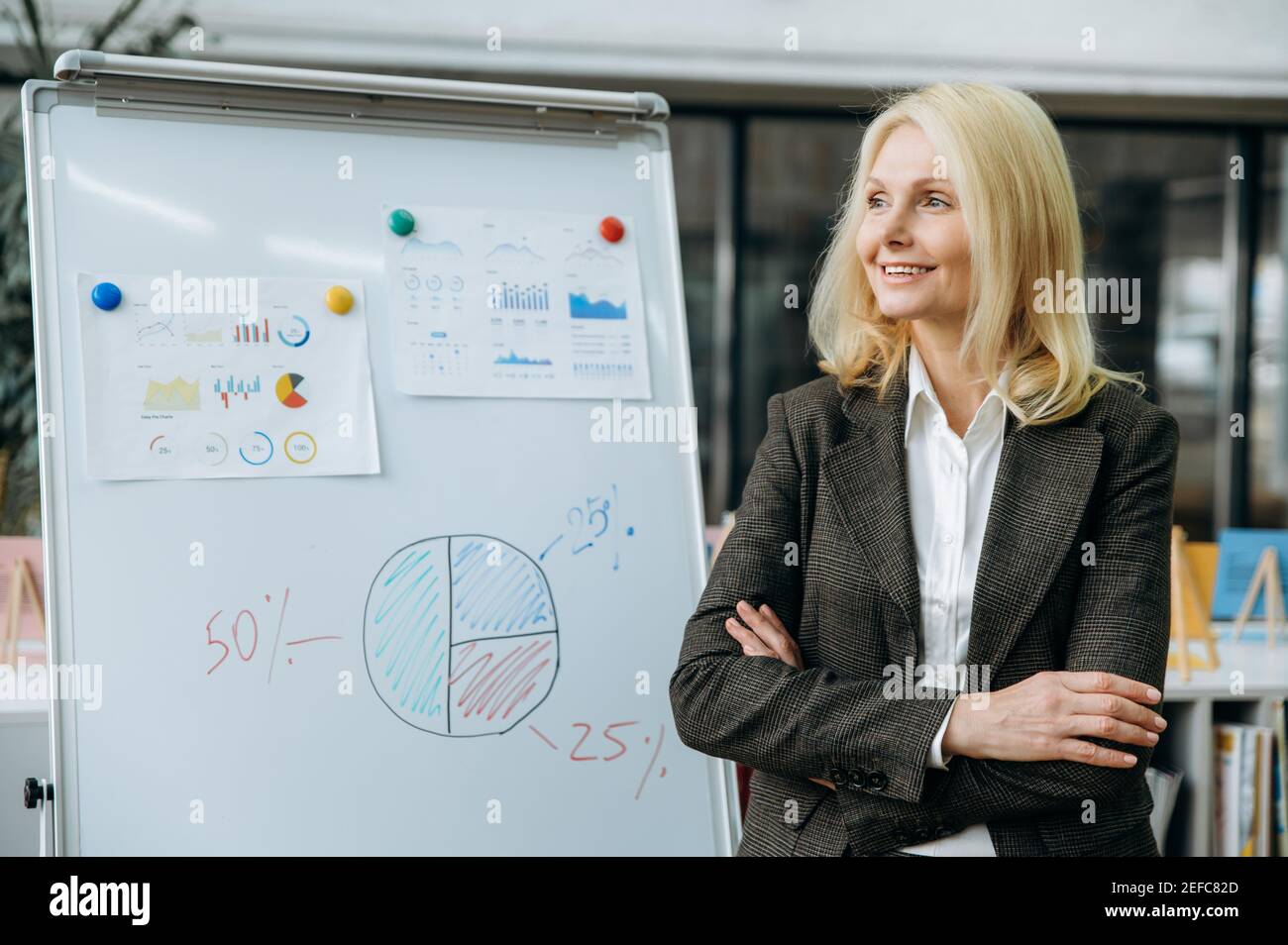 Influential successful female manager is standing in the office, posing ...
