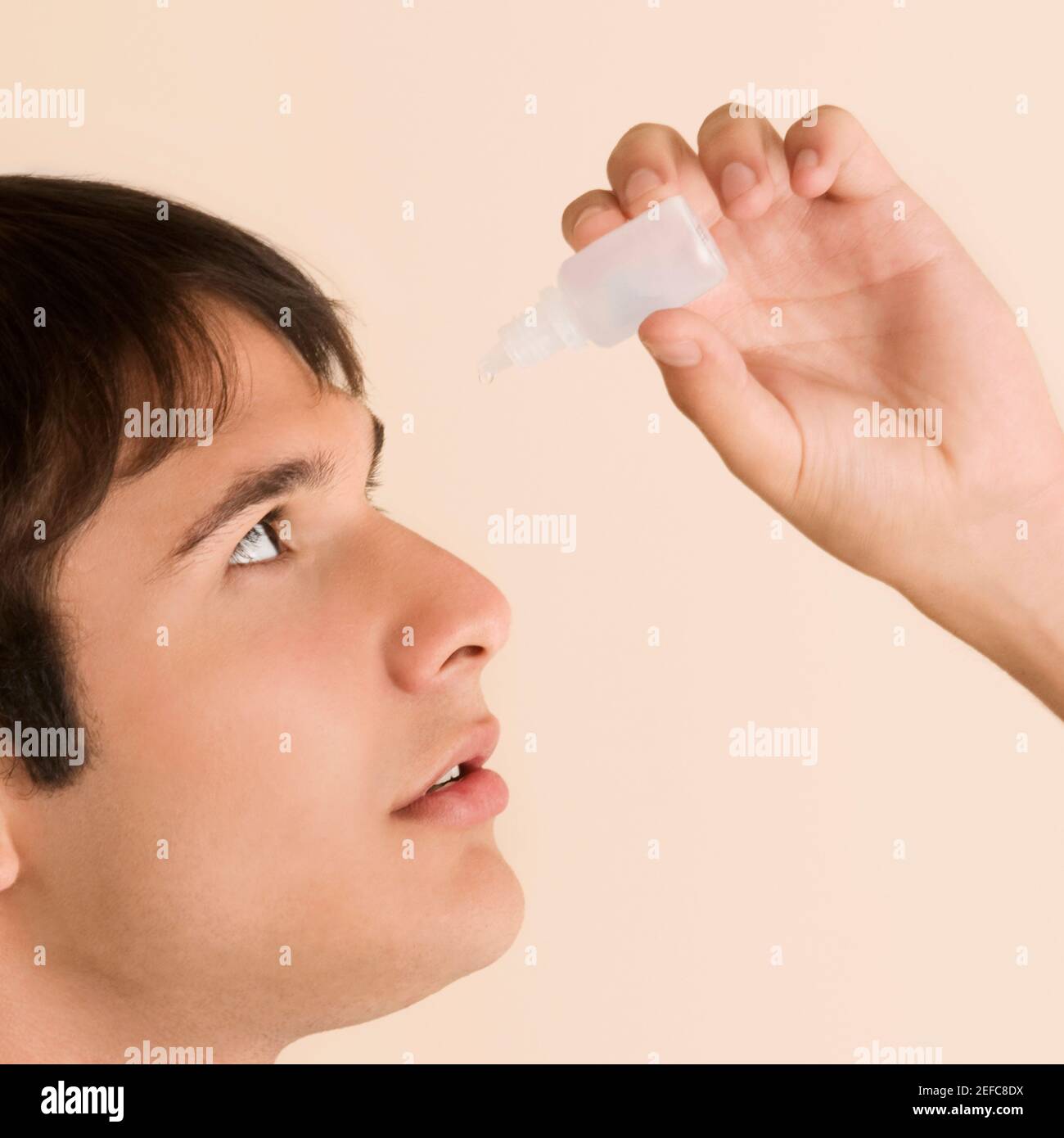 Close up of a young man putting eye drops in his eyes Stock Photo - Alamy