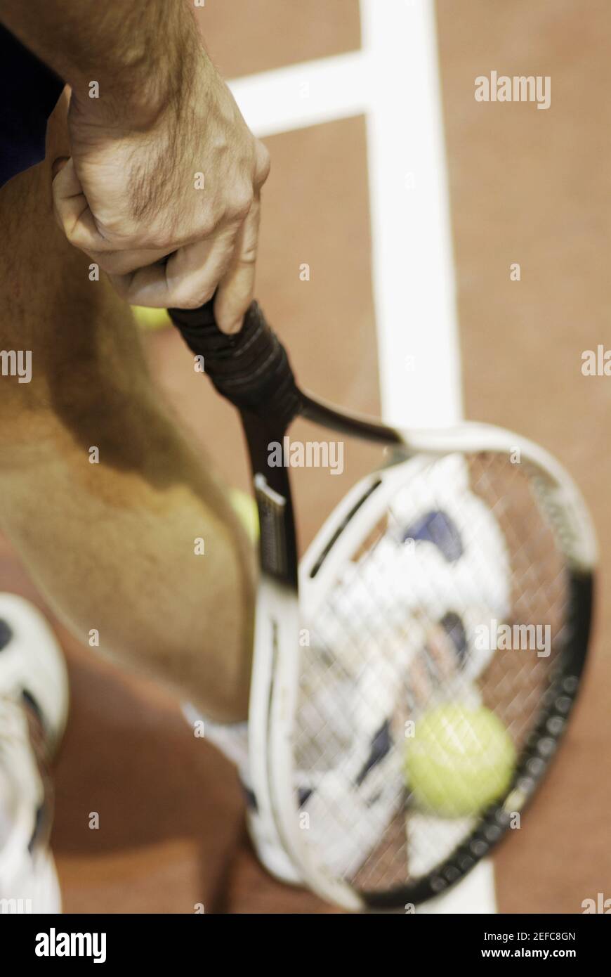 Low section view of a man holding a tennis racket Stock Photo - Alamy