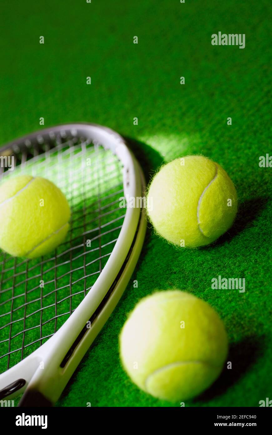 Close-up of three tennis bowls and a tennis racket Stock Photo - Alamy