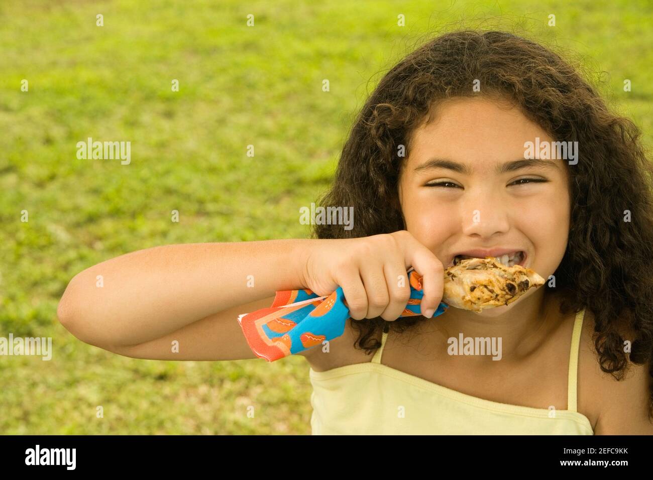 Portrait of a girl eating a chicken drumstick Stock Photo - Alamy