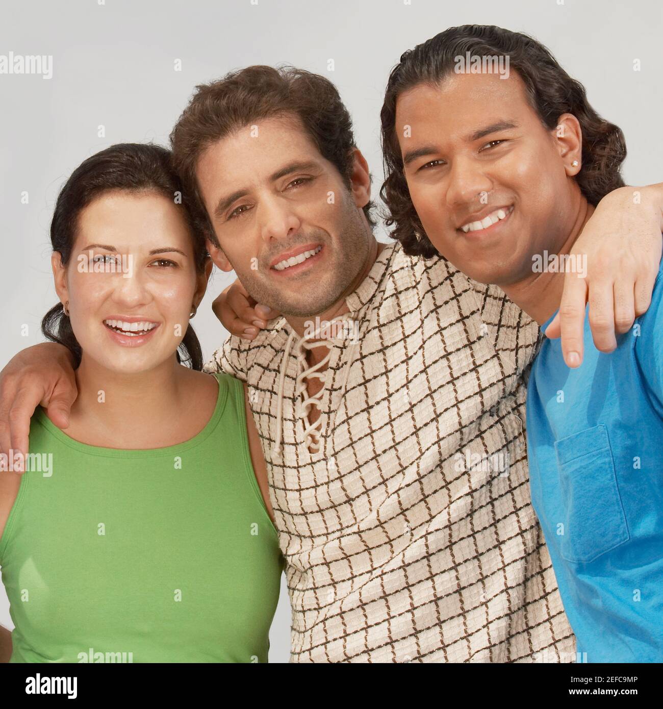 Portrait of three friends standing with their arms around each other ...