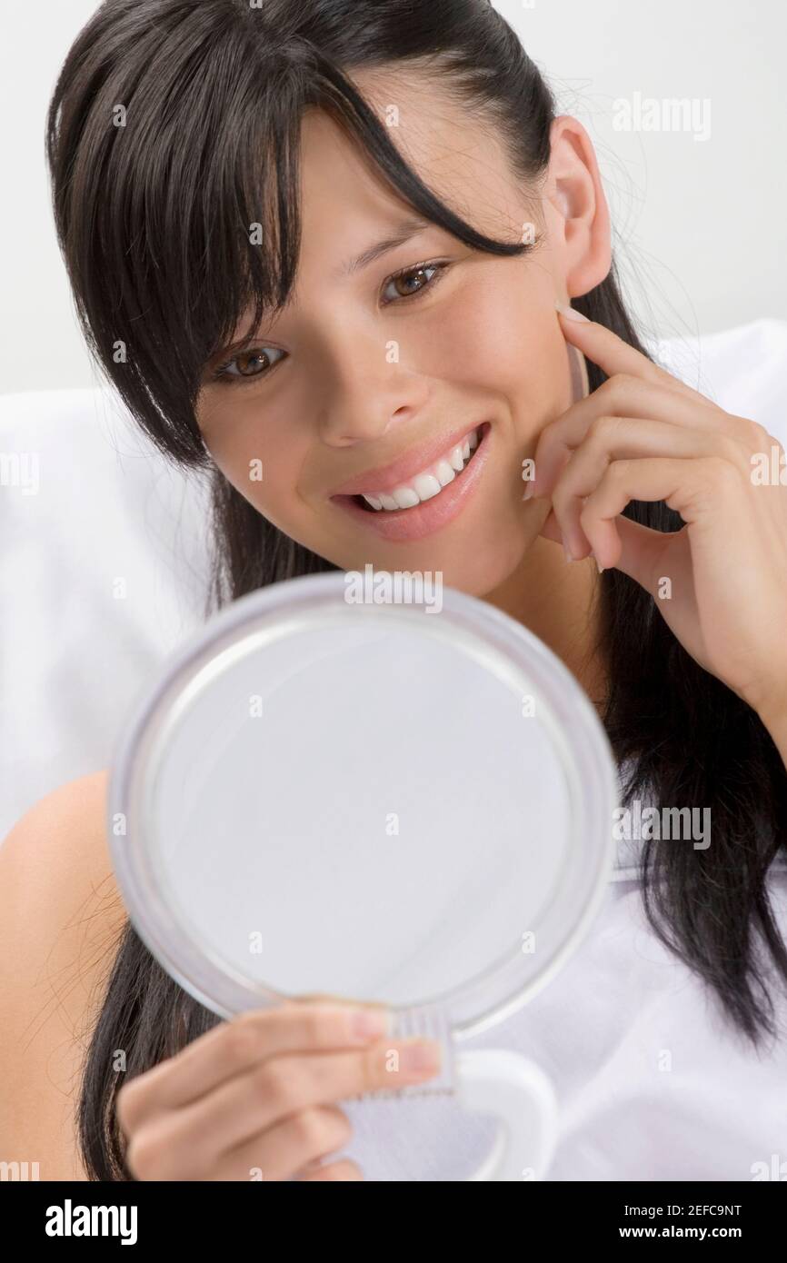 Female patient examining her face in a mirror Stock Photo - Alamy