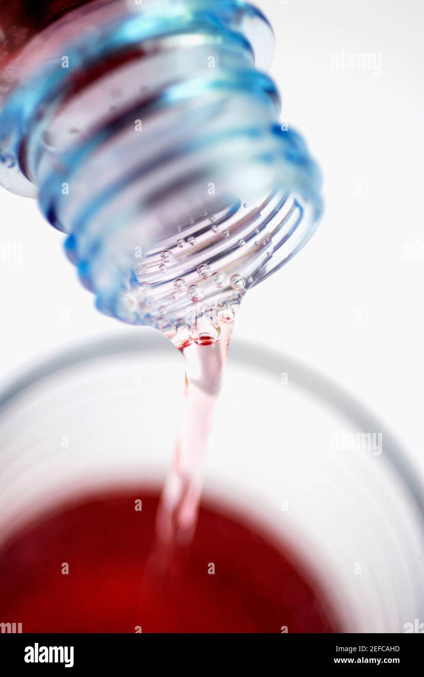 Liquid pouring from a bottle into a glass Stock Photo - Alamy
