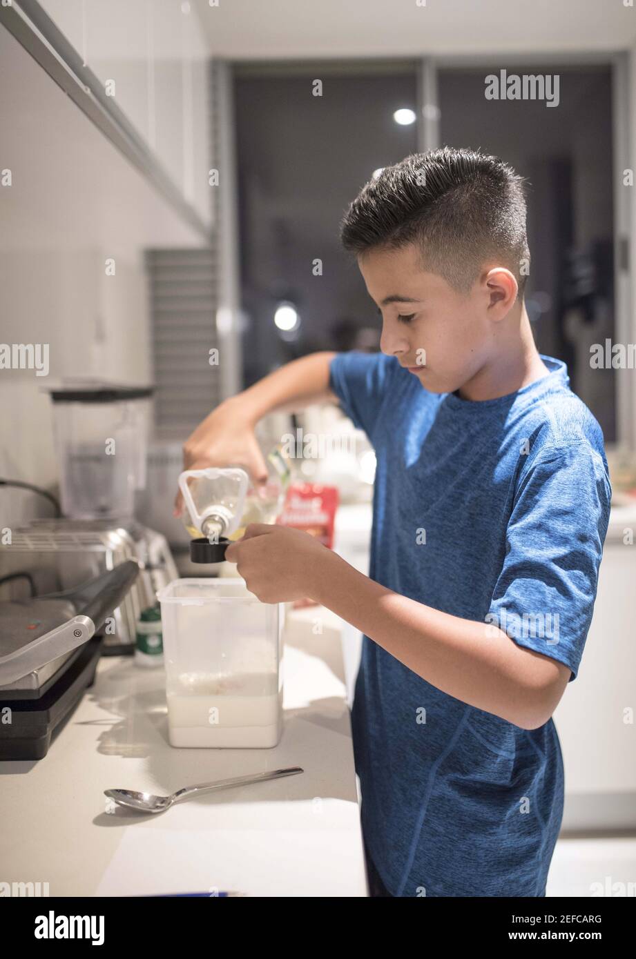 Teenager boy cooking in the kitchen at home Stock Photo - Alamy