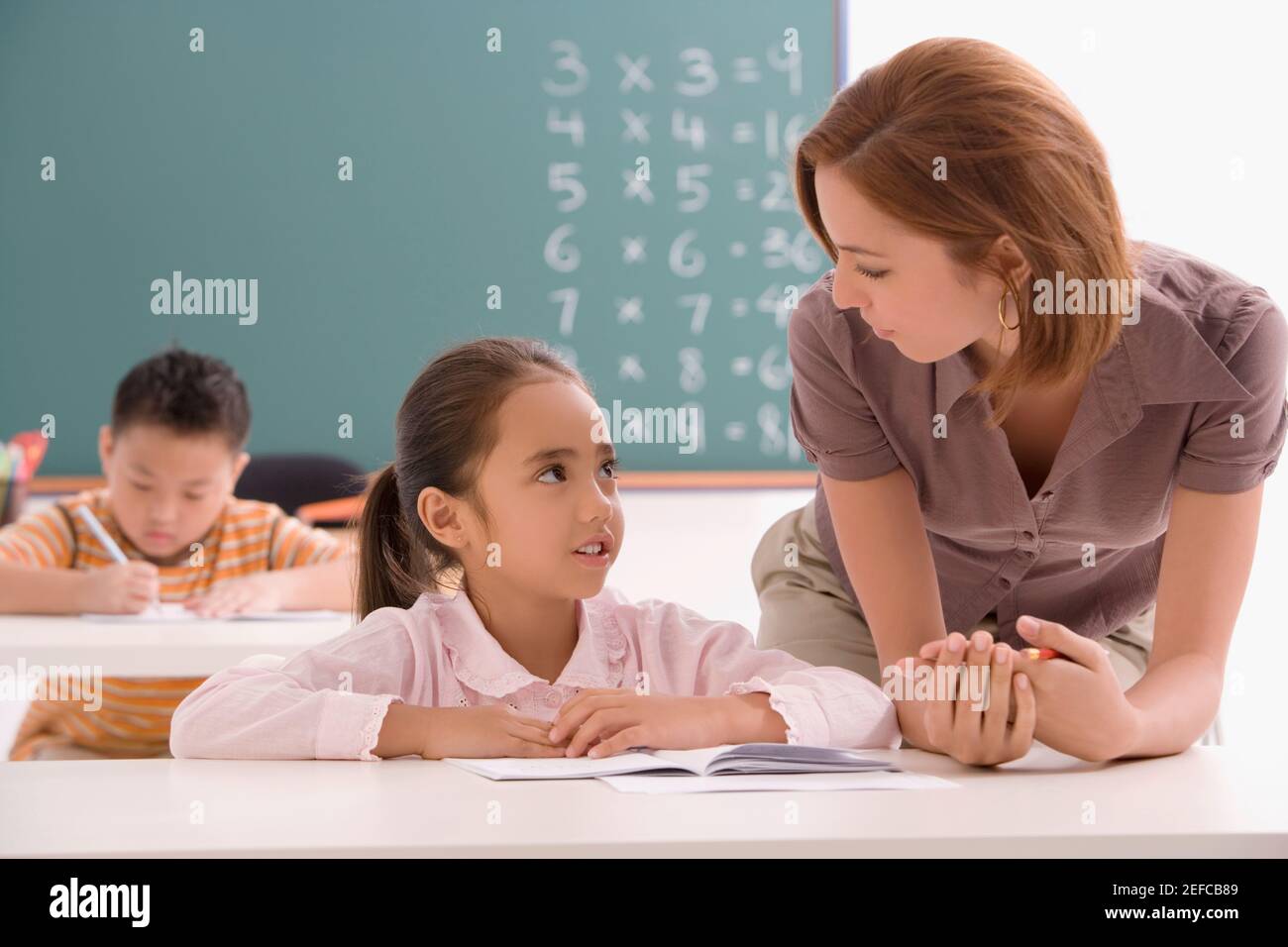 Female teacher teaching her student in a classroom Stock Photo - Alamy