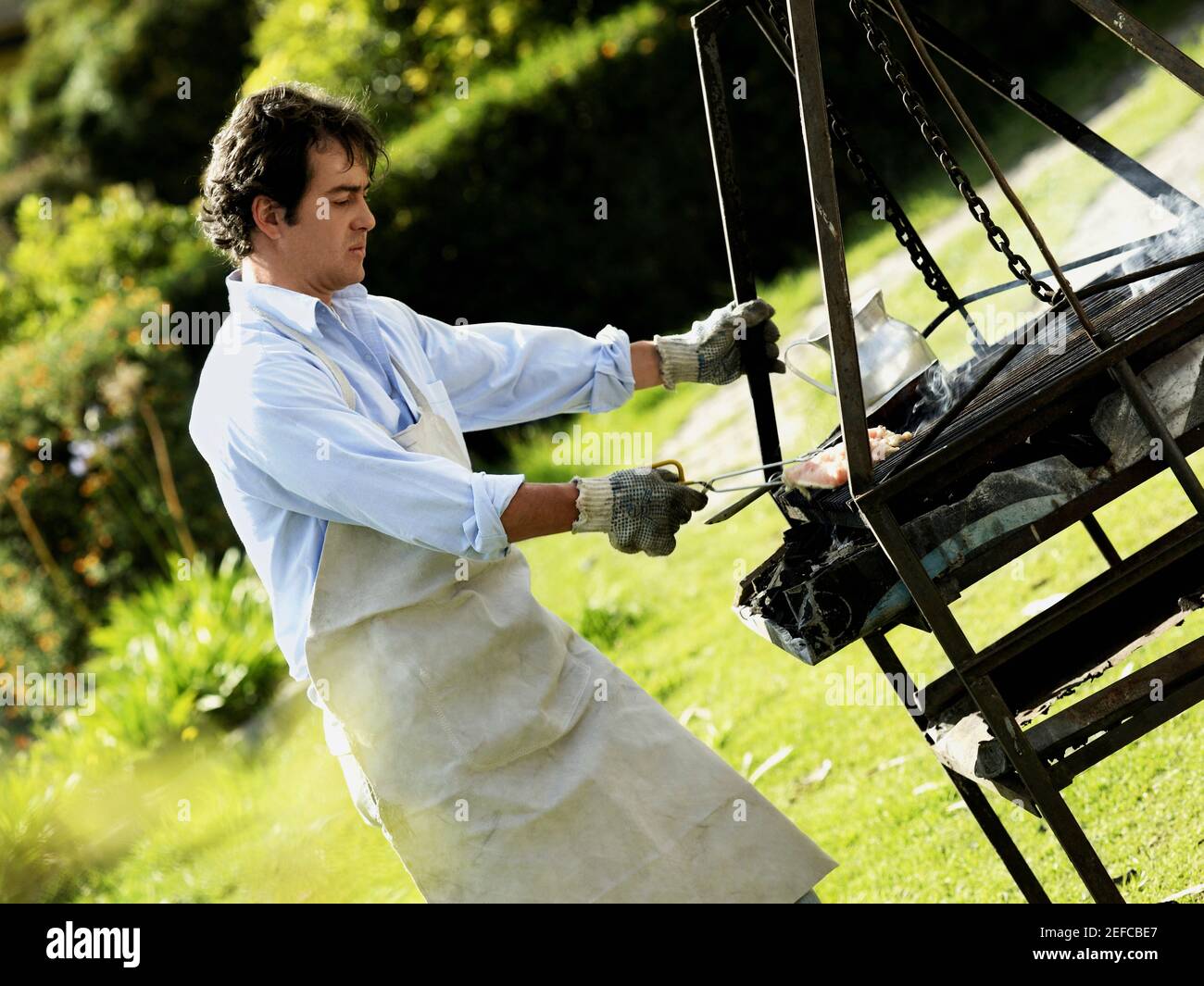 Side profile of a man cooking on a barbeque grill Stock Photo - Alamy
