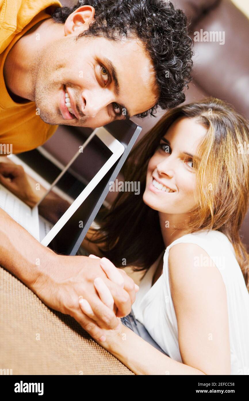 Portrait of a young couple lying down and holding hands Stock Photo - Alamy
