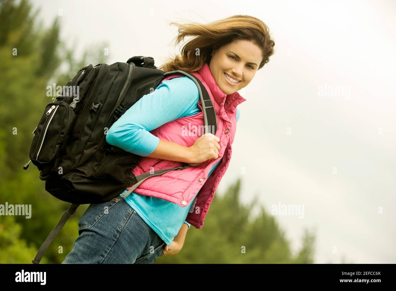 Portrait of a young woman carrying a backpack Stock Photo - Alamy