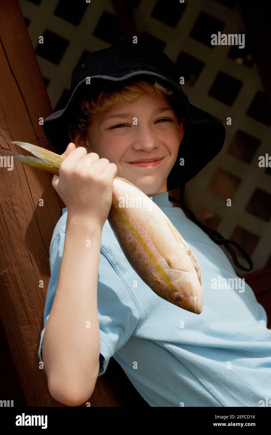 Portrait of a boy holding a fish and smiling Stock Photo - Alamy