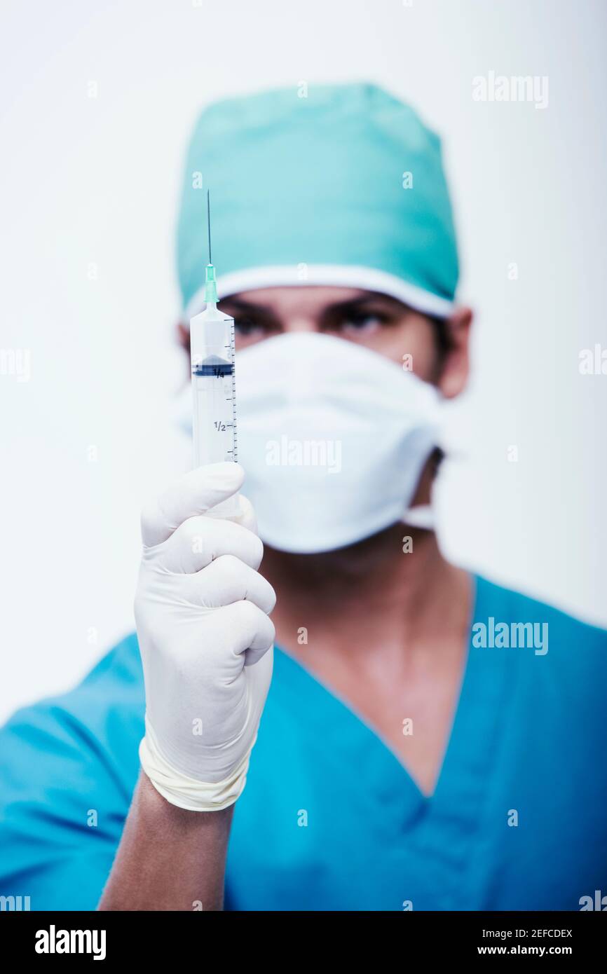 Close-up of a surgeon in scrubs holding a syringe Stock Photo - Alamy
