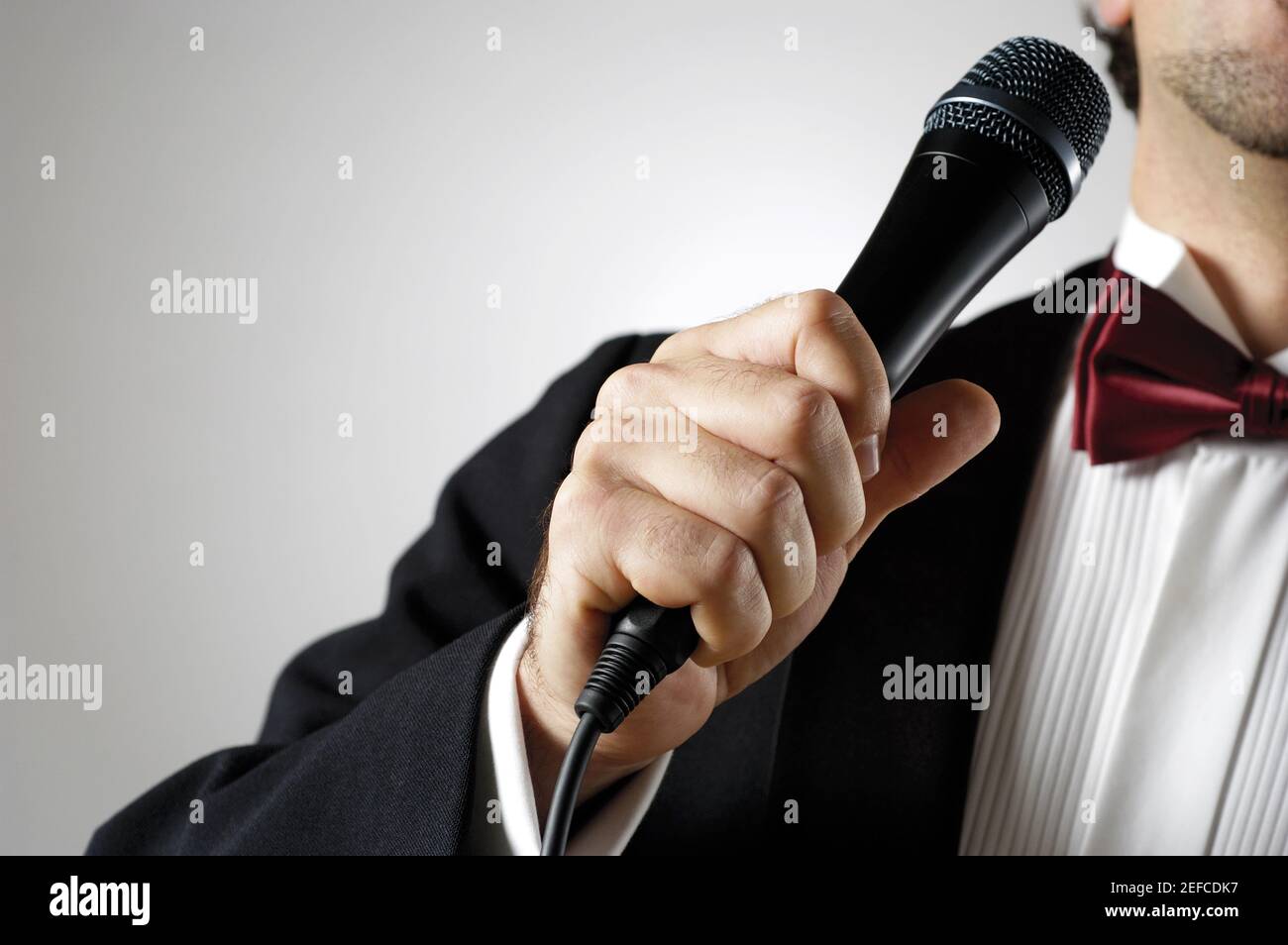 Young man holding a microphone Stock Photo - Alamy