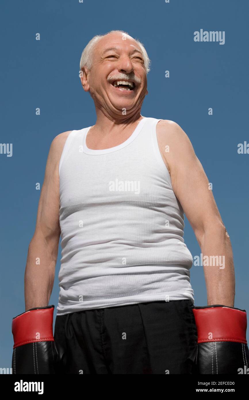 Senior man wearing boxing gloves and smiling Stock Photo - Alamy