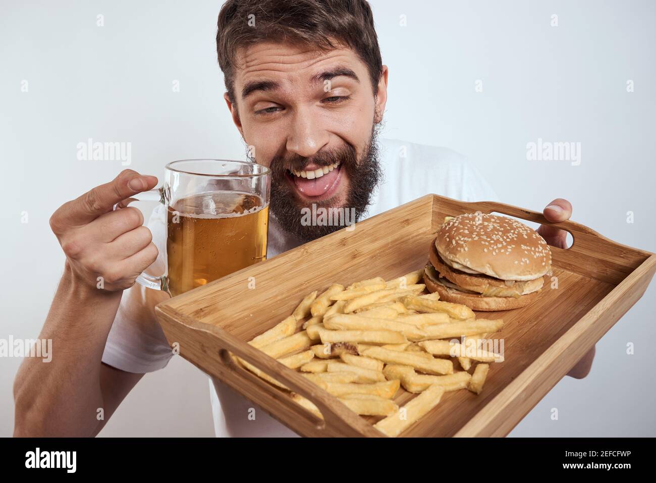 Man with a mug of beer fast food diet food alcohol fun light background ...