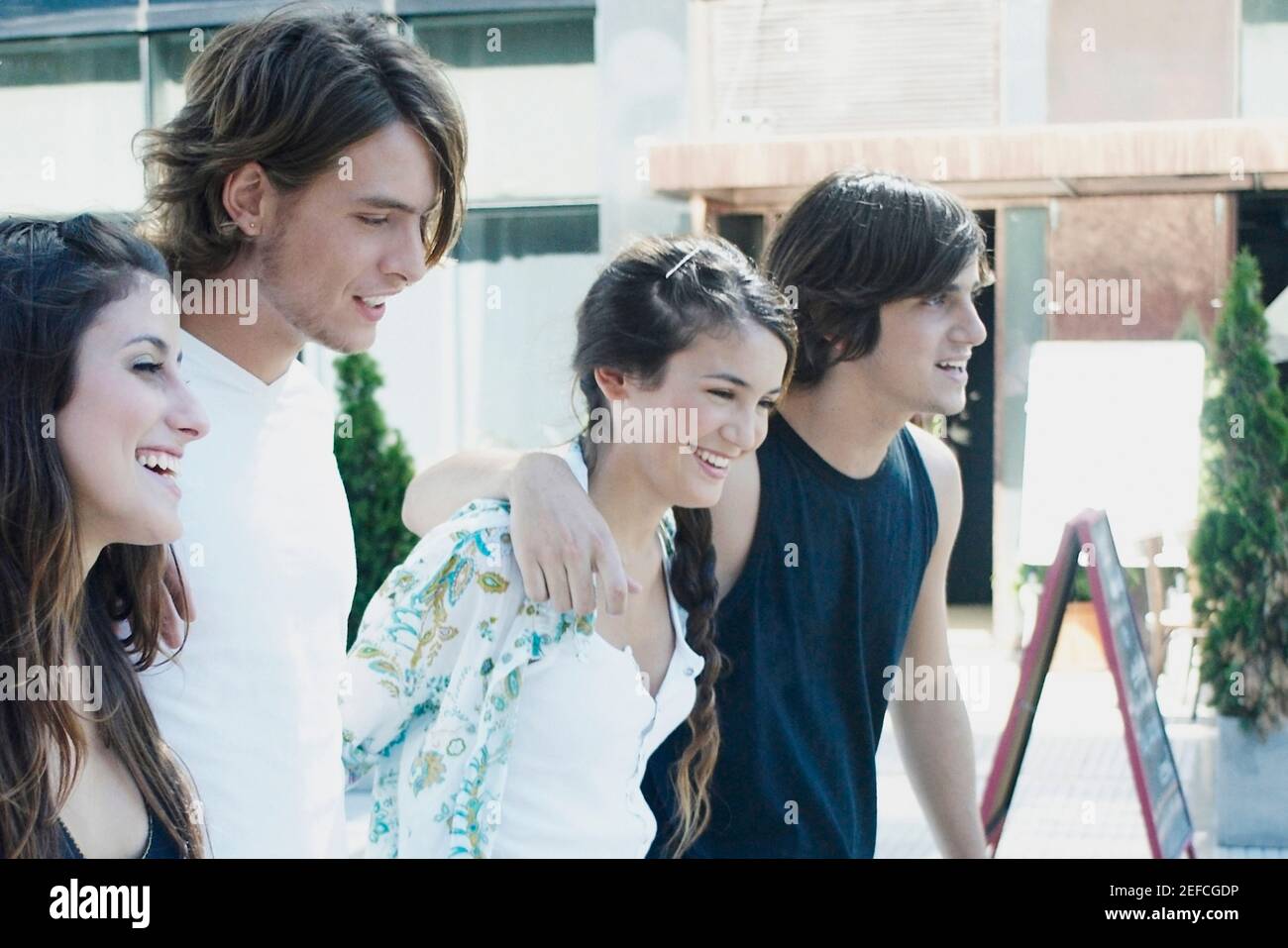 Group of friends walking together with their arms around each other ...