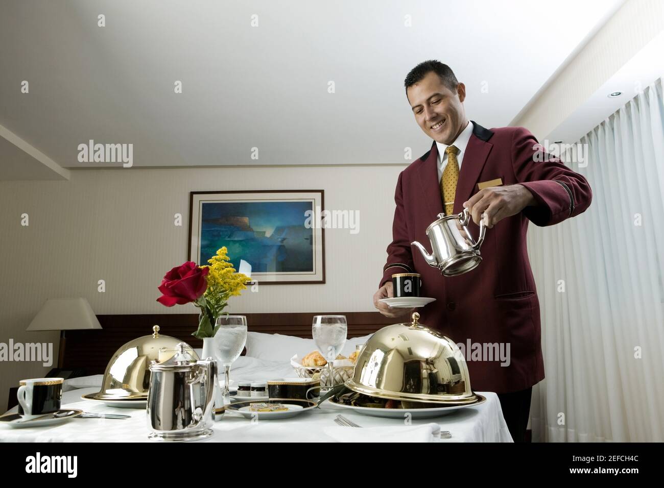 Waiter pouring tea in a cup Stock Photo - Alamy