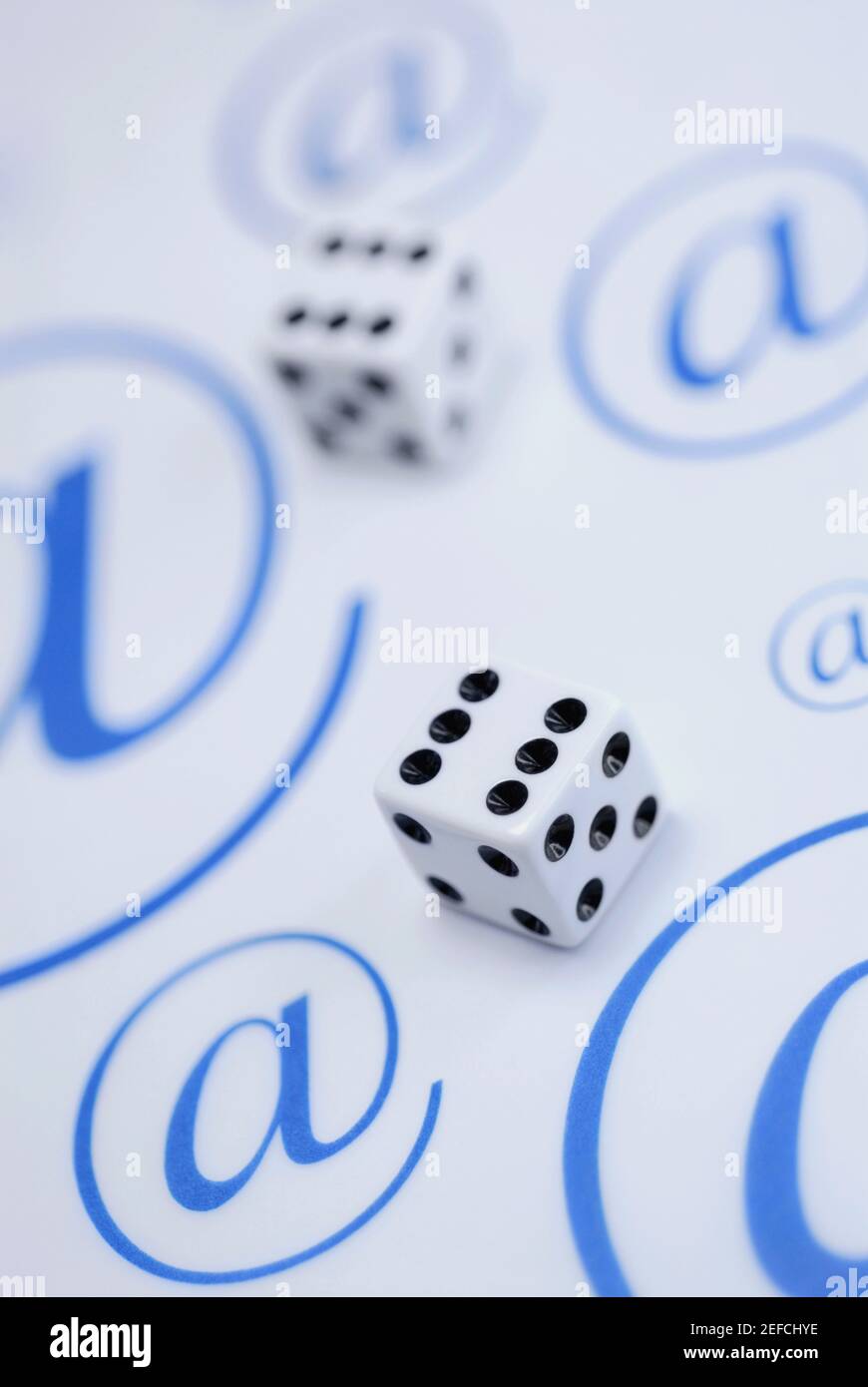 Close up of two dices on a sheet of paper with At symbols Stock Photo ...