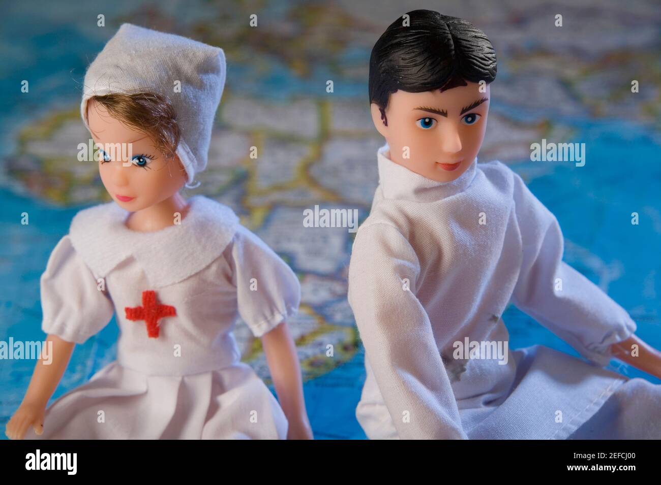 Close up of two dolls sitting on a map Stock Photo - Alamy