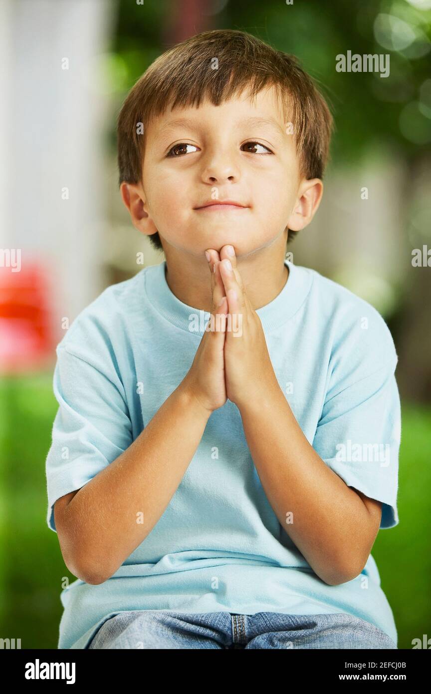 Close up of a boy sitting in a prayer position Stock Photo - Alamy