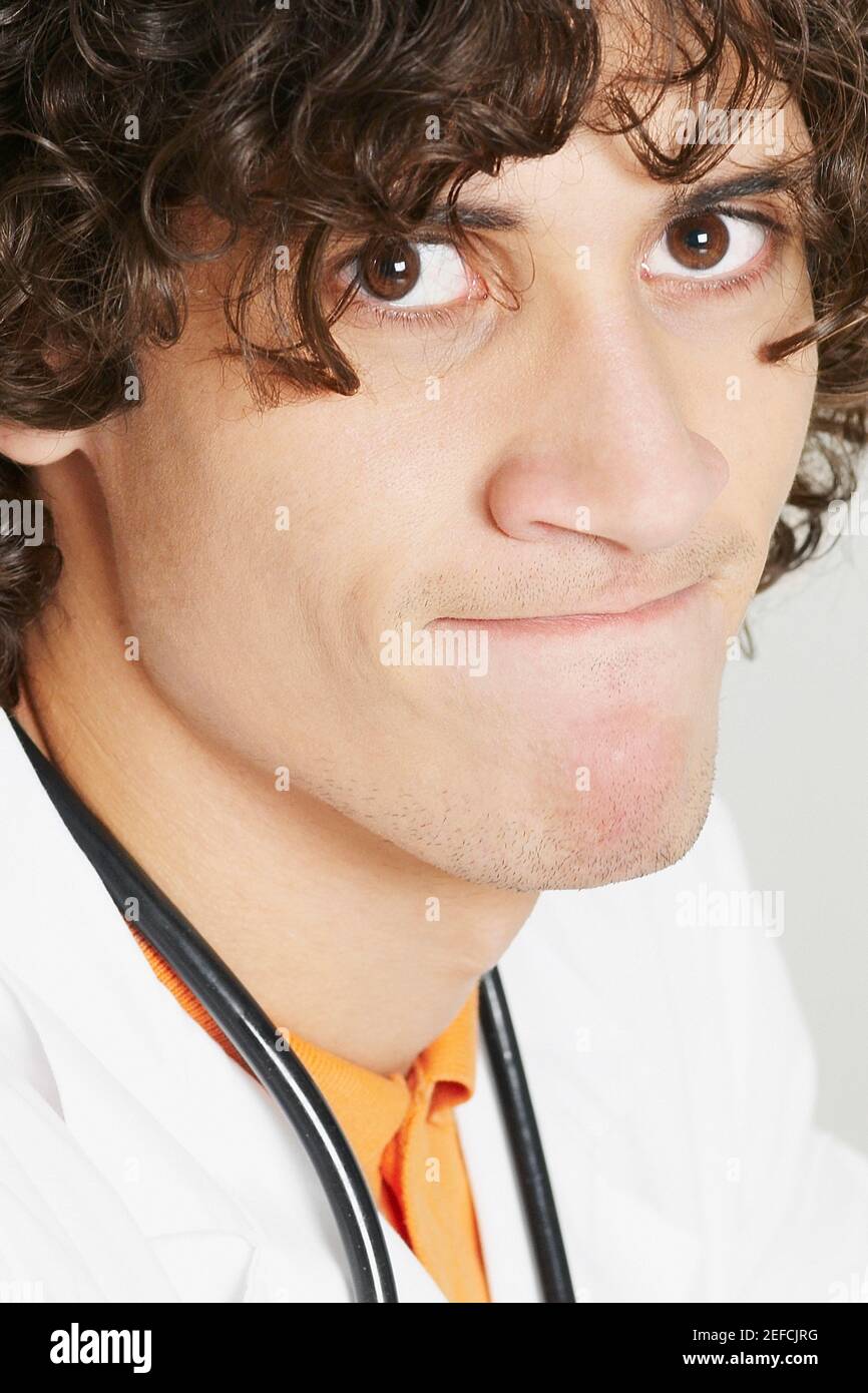 Portrait of a male doctor biting his lips Stock Photo - Alamy